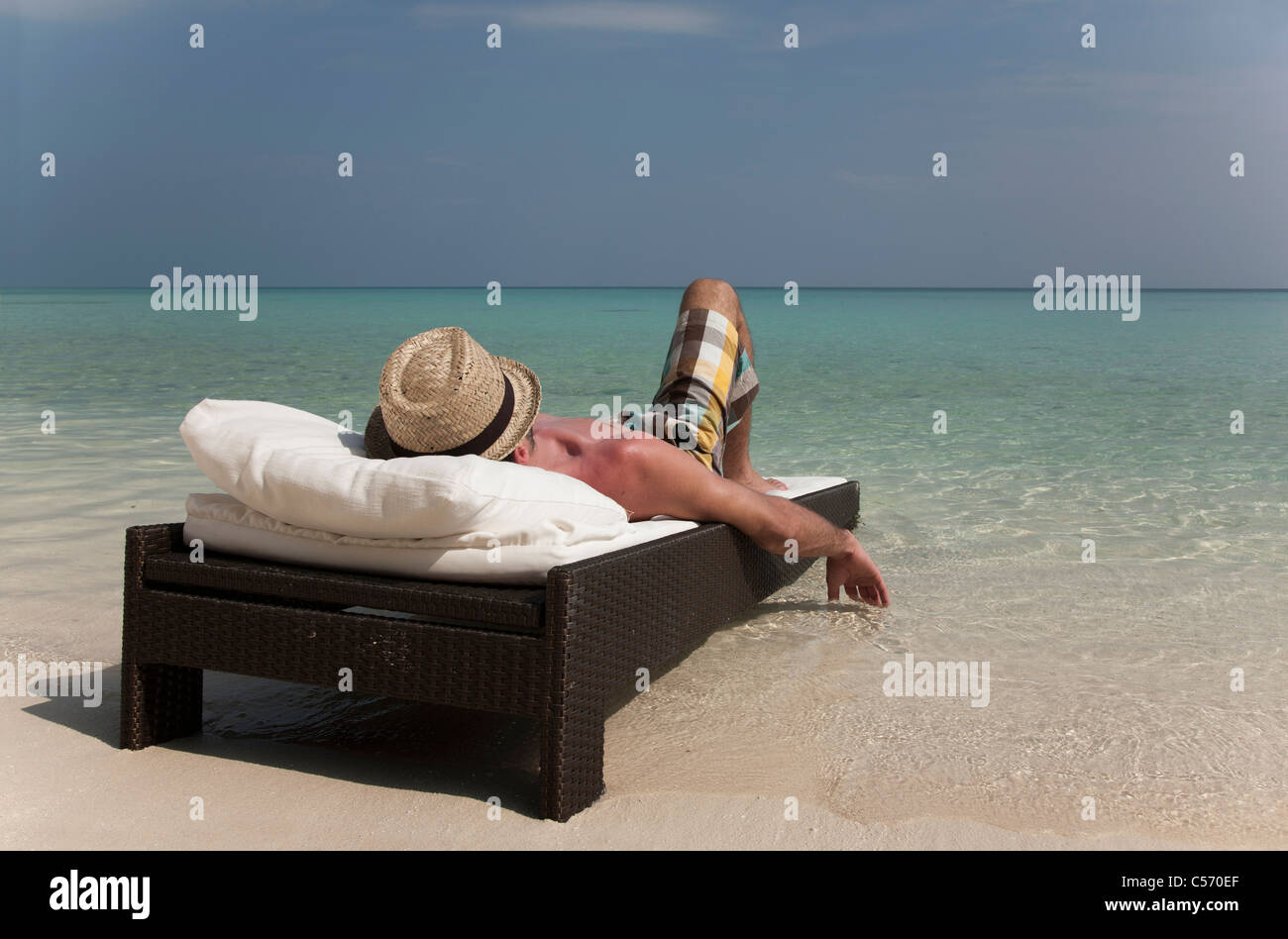 Mann auf der Liege am tropischen Strand entspannen Stockfotografie - Alamy