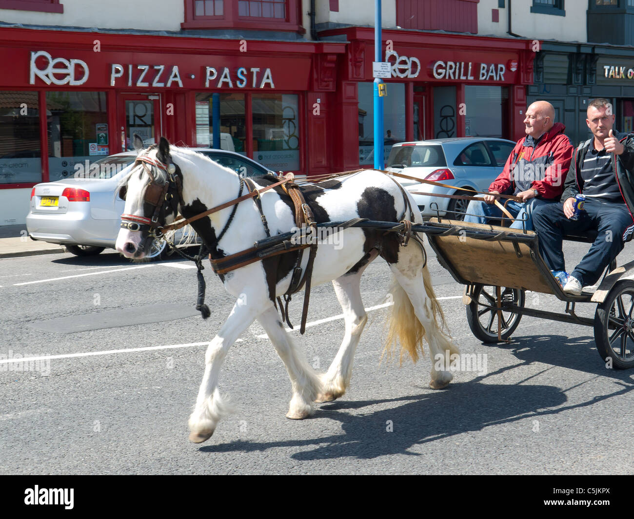 Zwei Männer, die einem Zigeuner Trab Wagen, gezogen von einem schwarz ...