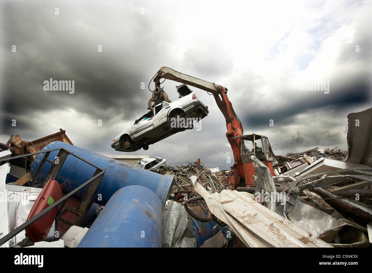 Kran mit Greifer heben Schrottauto zum recycling in einem Schrottplatz ...