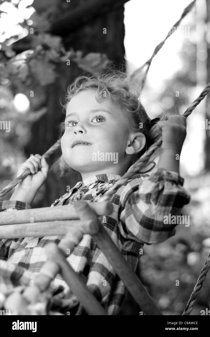 Kleine und hübsche Mädchen auf einer Schaukel spielen Stockfotografie ...