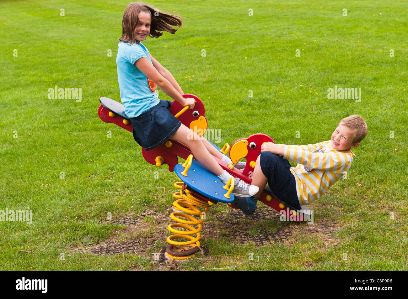 Ein Mädchen und jungen (10 und 8) spielen auf einer Wippe in Uk Park ...