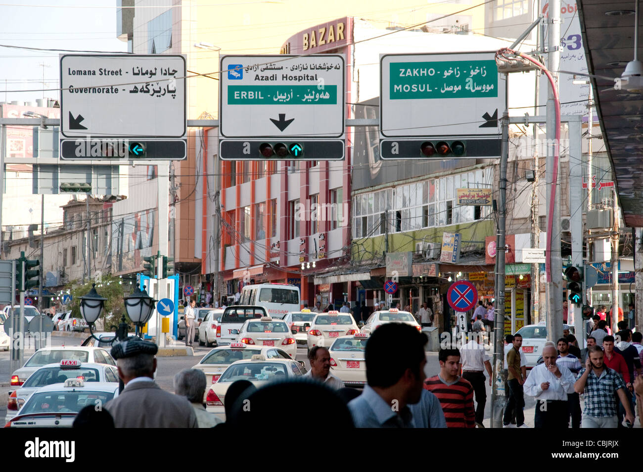 Auto- und Fußgängerverkehr entlang einer verkehrsreichen Hauptstraße in ...