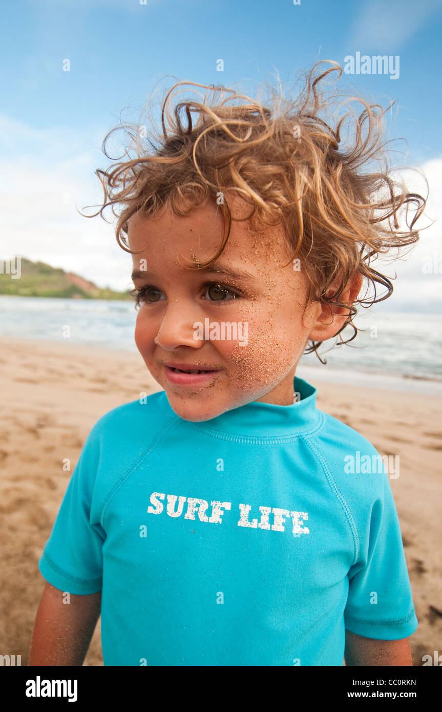 Adorable kleine surf Junge mit langen Locken am Strand Hanalei Bay ...