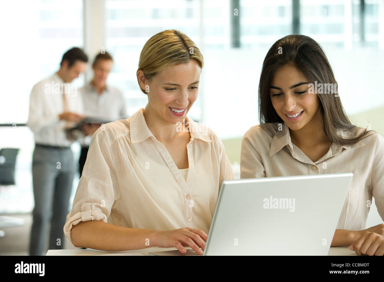 Kollegen, die an ihren schreibtischen im alter von 20 jahren arbeiten ...