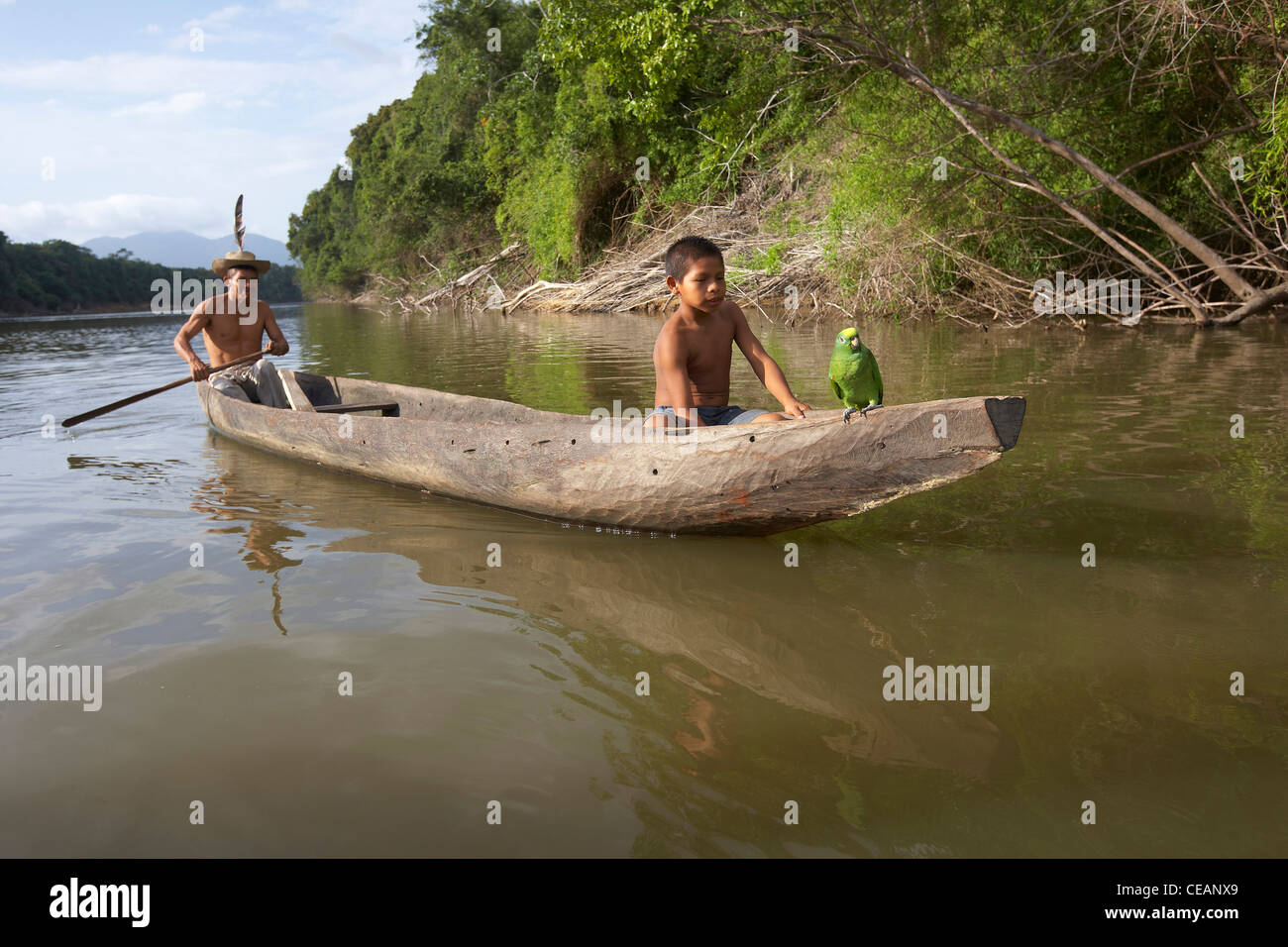 Indianische Dorfbewohner und junge mit Papagei Kanu Einbaum entlang der ...