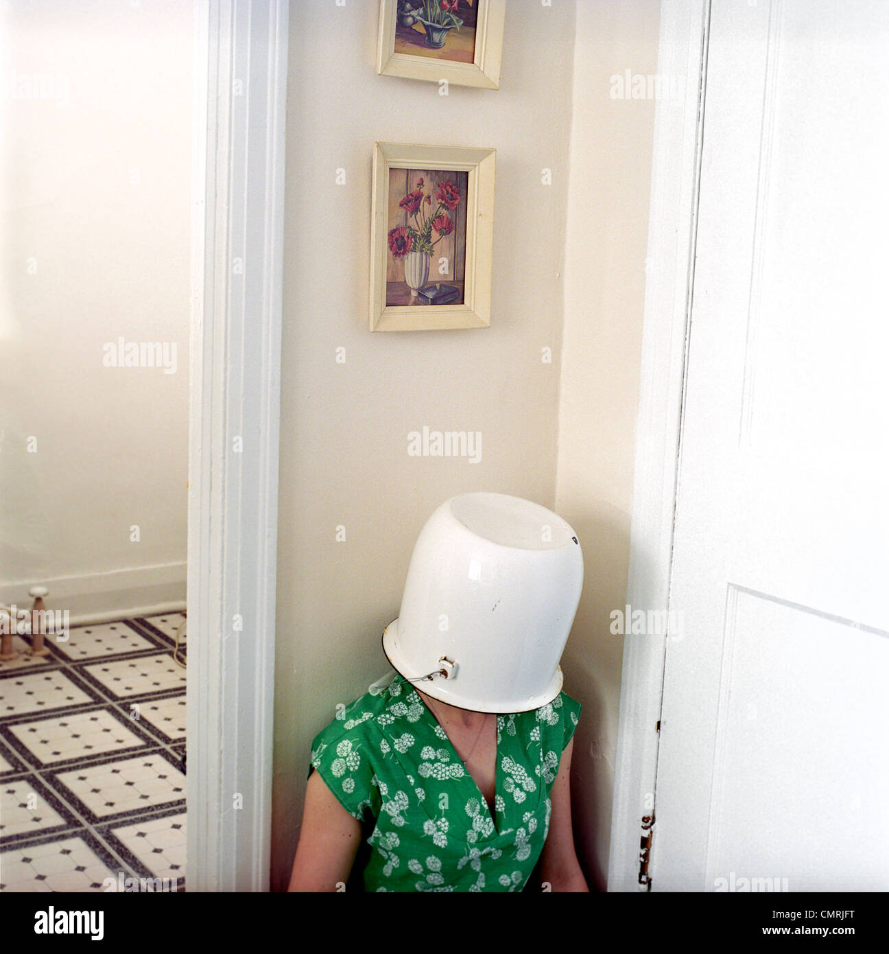 Frau sitzt in der Ecke mit Topf auf Kopf Stockfotografie - Alamy
