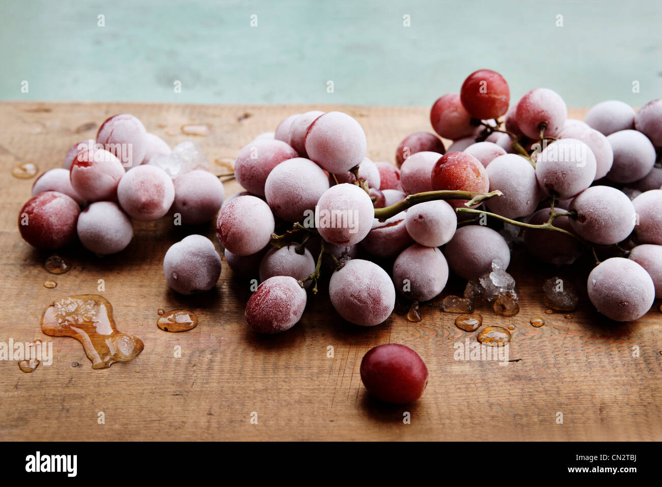 Gefrorene Trauben rd auf Schneidbrett aus Holz Stockfotografie - Alamy
