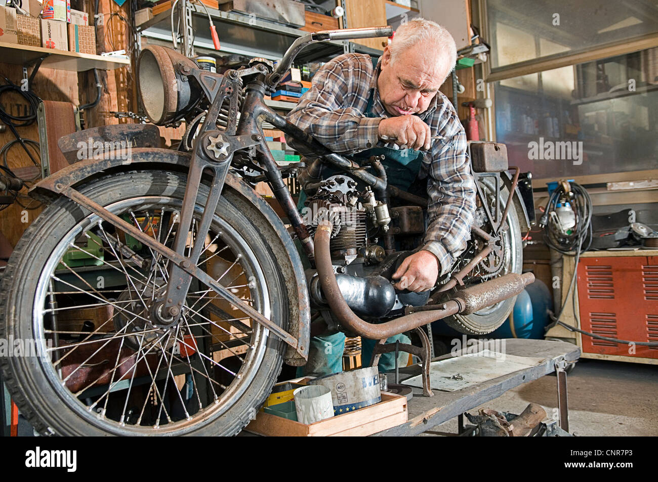 Mann in seiner Werkstatt ein Oldtimer Motorrad zu reparieren ...
