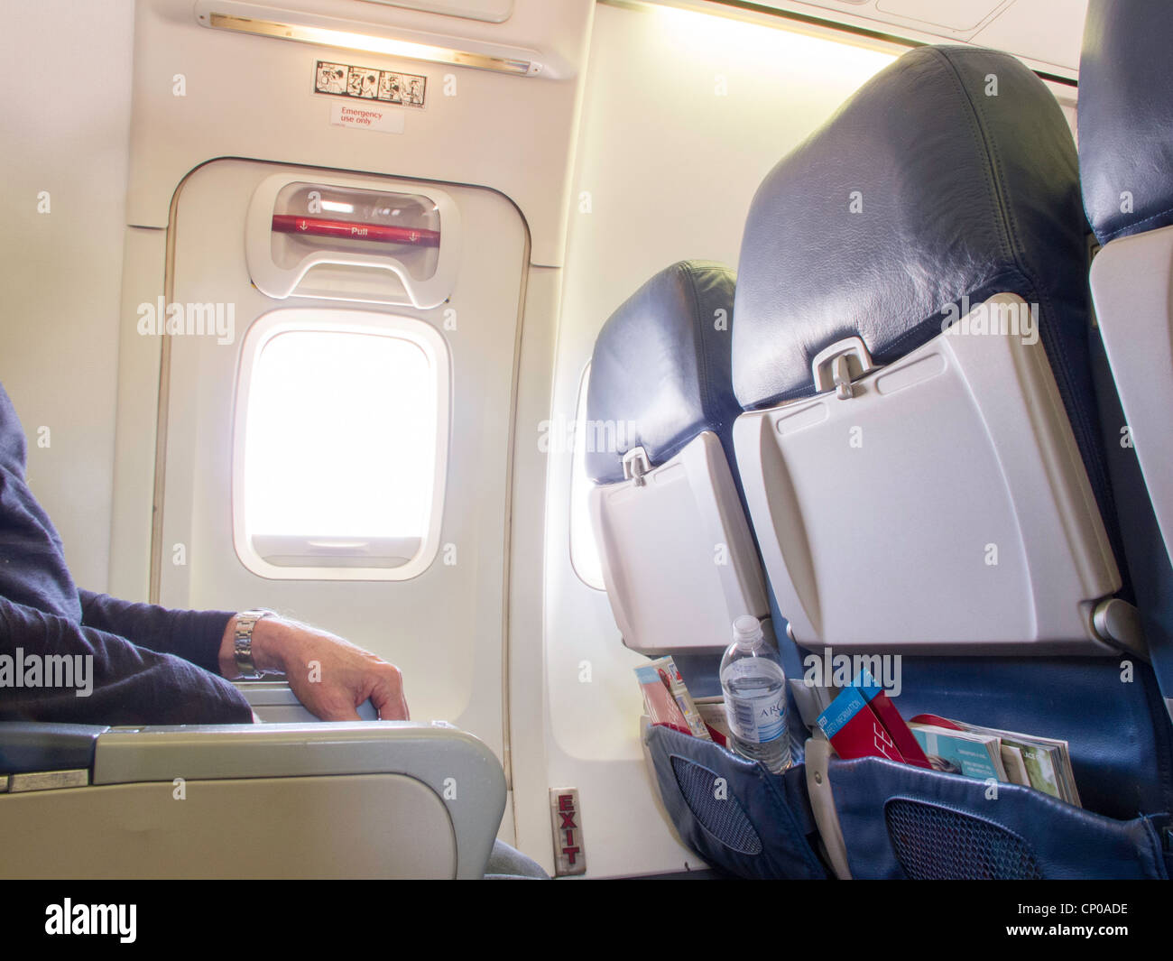Männlichen Passagier sitzt im Notausgang im Flugzeug Stockfotografie ...