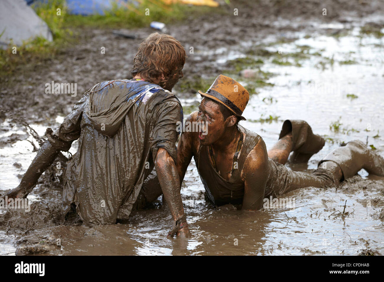Jungs spielen im Schlamm beim Musikfestival in Großbritannien ...