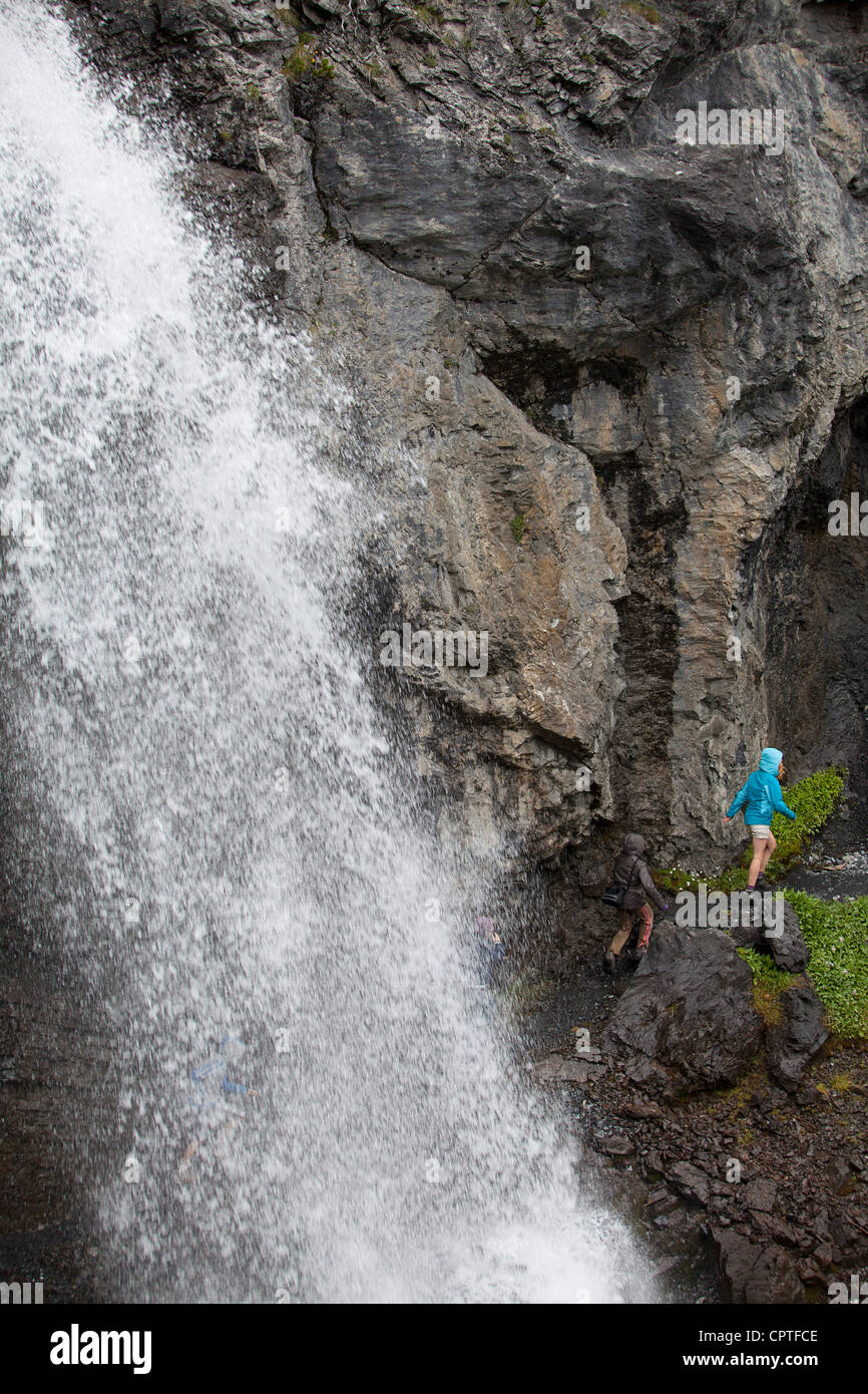Kinder laufen hinter einem Wasserfall in Trafoi-Tal, Italien ...