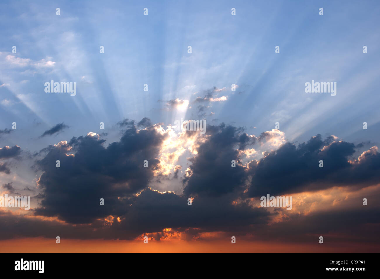 Die Strahlen der untergehenden Sonne hinter den Wolken und blauer ...