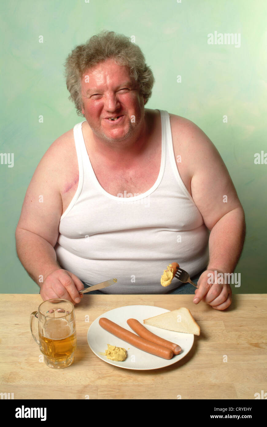 Fetter Mann im Unterhemd essen zwei Würstchen mit Senf Stockfotografie ...