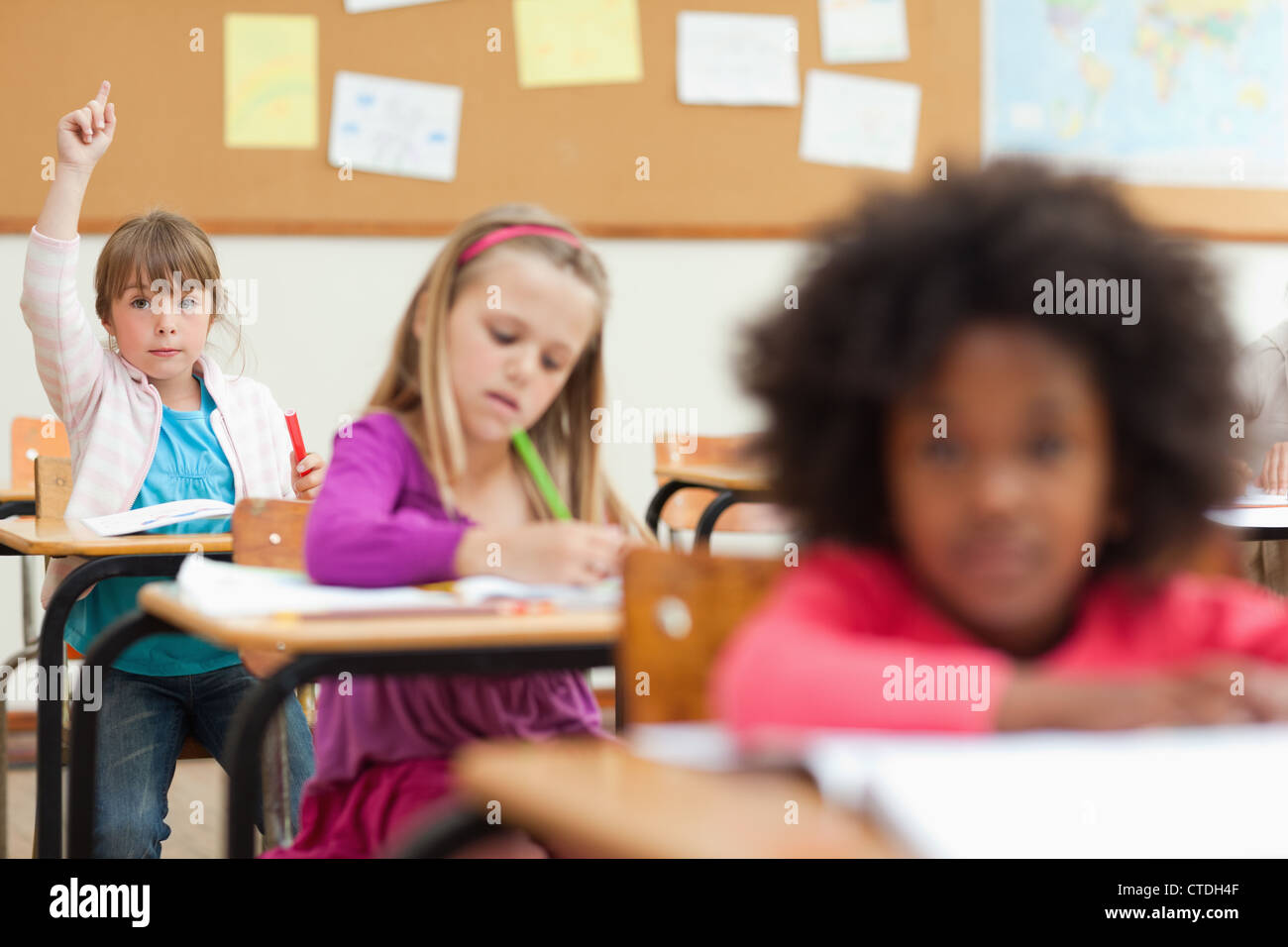 Schulmädchen, das ihre hand in der klasse anhebt -Fotos und ...