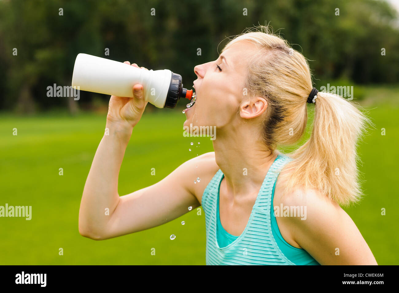 Junge schöne blonde Frau Trinkwasser im grüne Sommerpark ... Junge schöne blonde Frau Trinkwasser im grüne Sommerpark ...