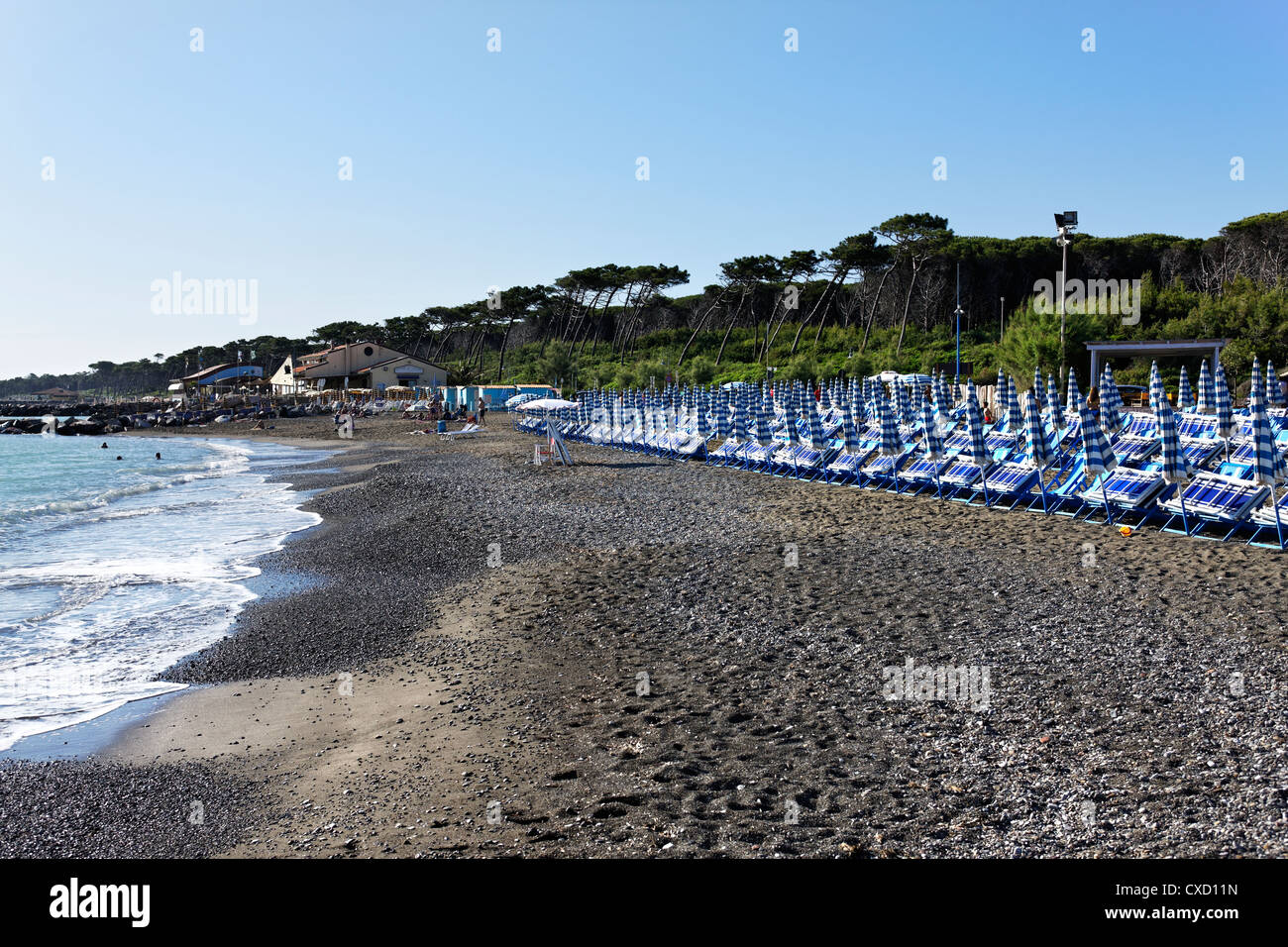 Blaue und weiße Sonnenschirme und Liegestühle am Strand Le Gorette ...