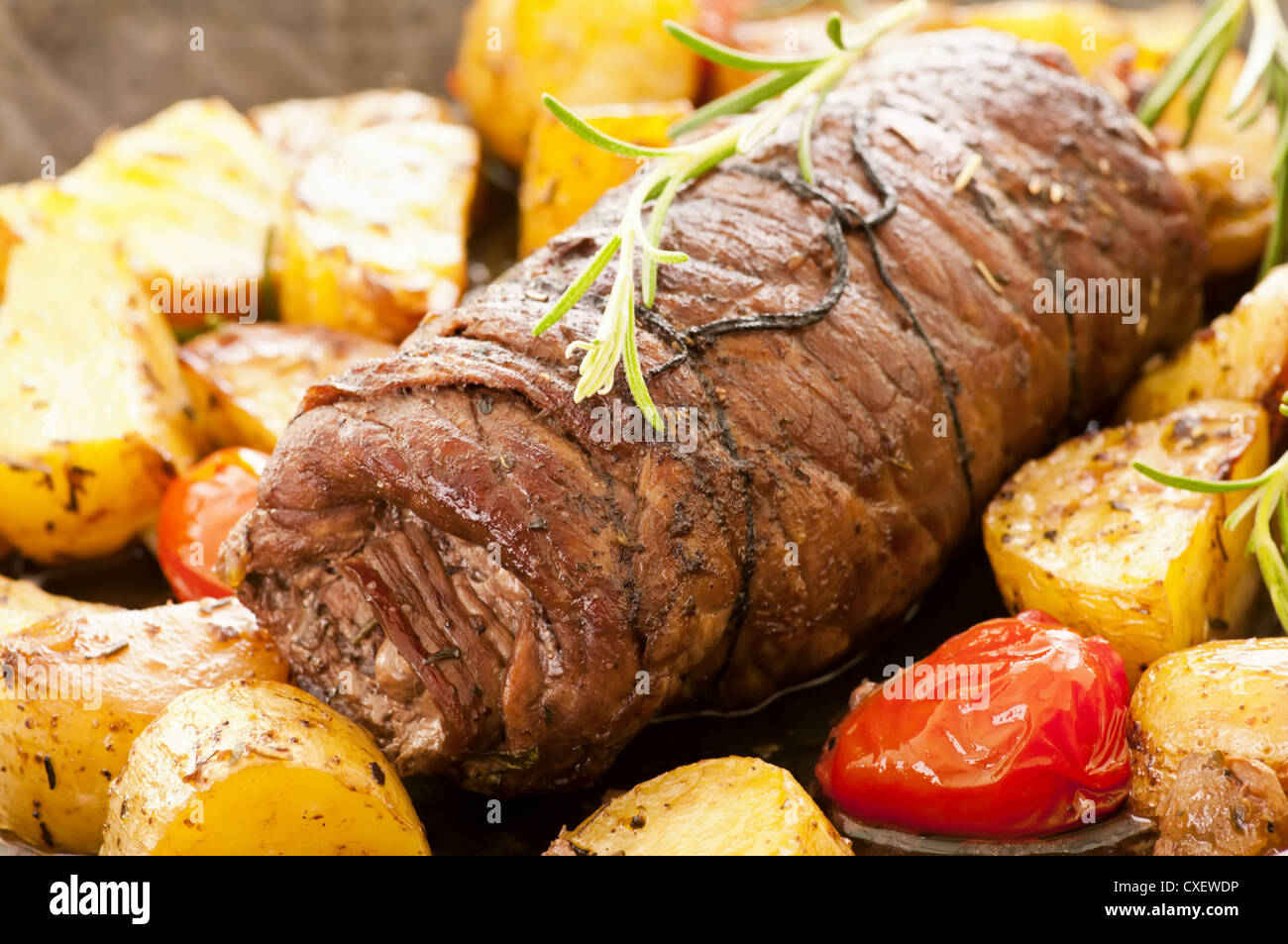 Rindsroulade mit gerösteten Kartoffeln und Tomaten Stockfotografie - Alamy