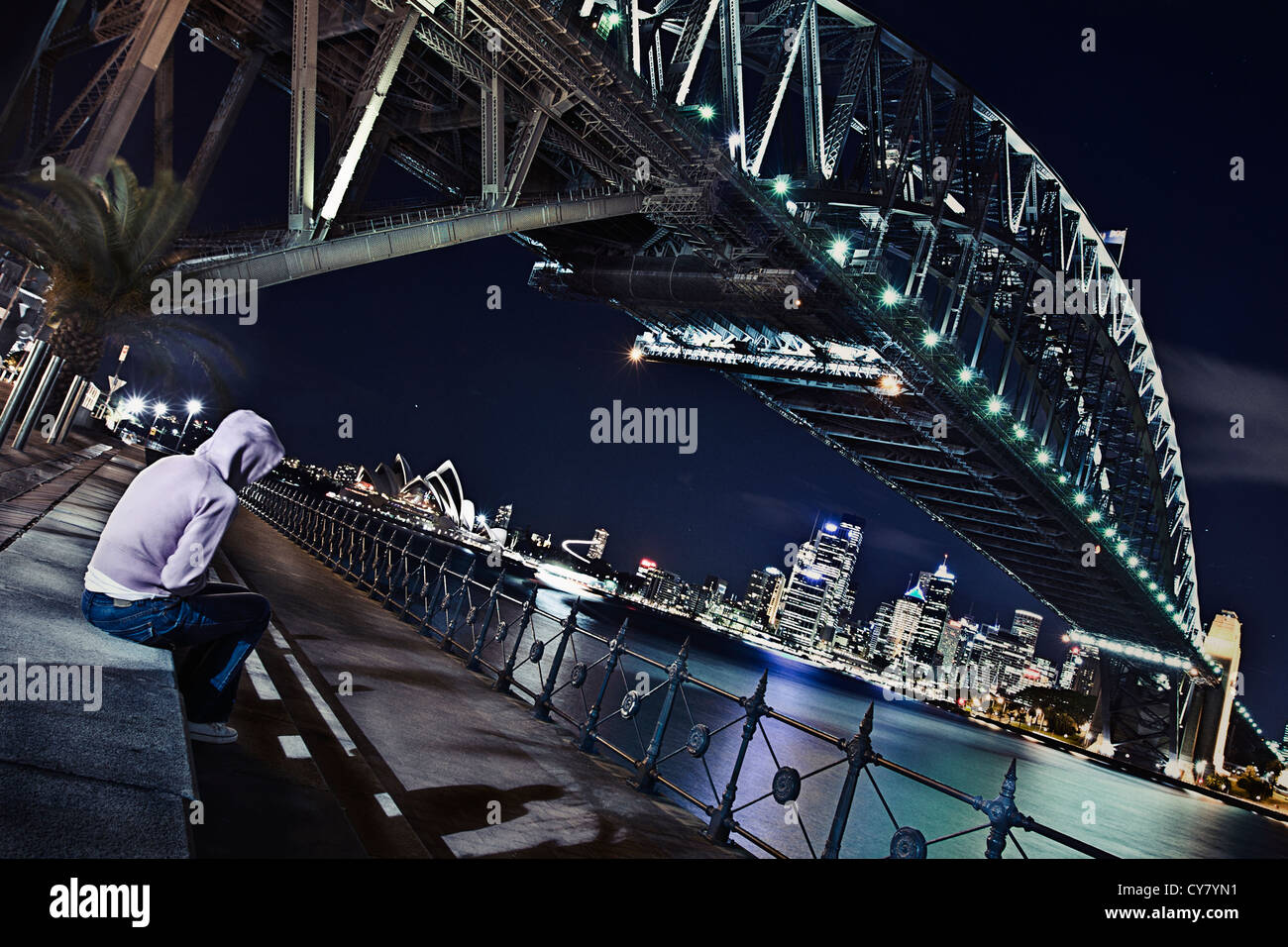 Vermummte Person sitzt unter der Sydney Harbour Bridge Stockfotografie ...