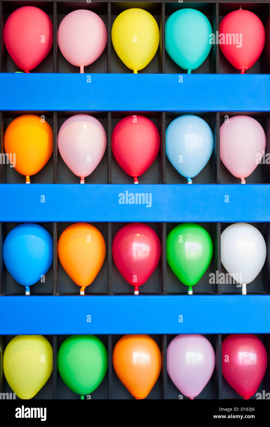 Eine blaue Wand-Gehäuse mit bunten Luftballons. Foto ist von einer ...