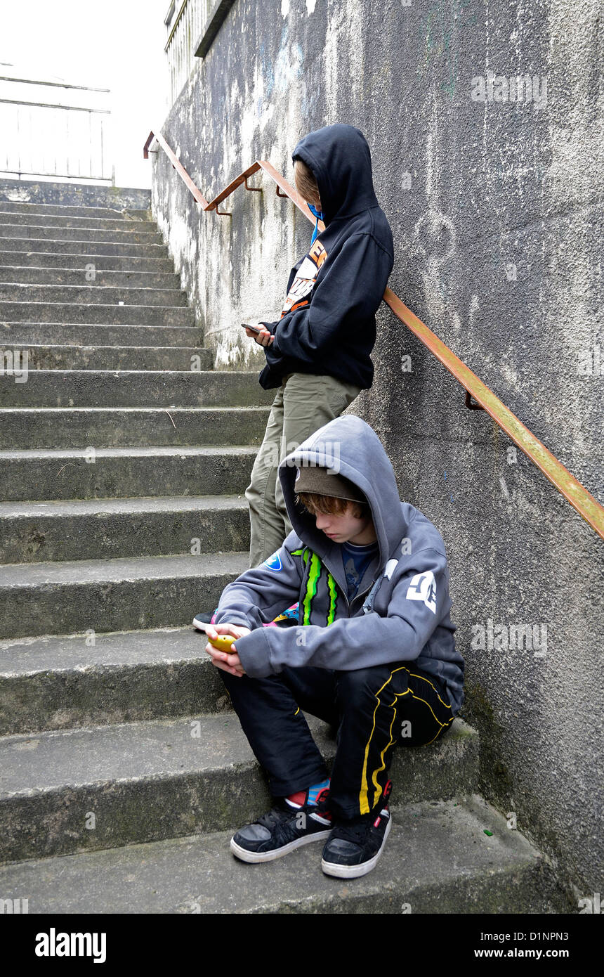 zwei Jungs im Teenageralter SMS mit Handys Stockfotografie - Alamy