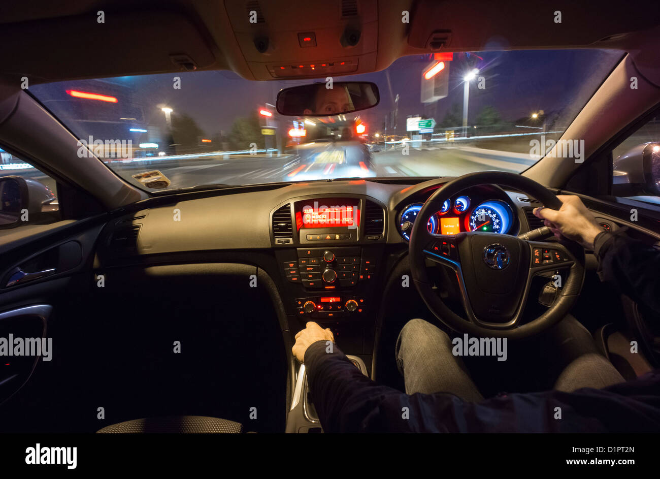 Nachtfahrten schnell zu einem stationären Auto an der Ampel aus im ...