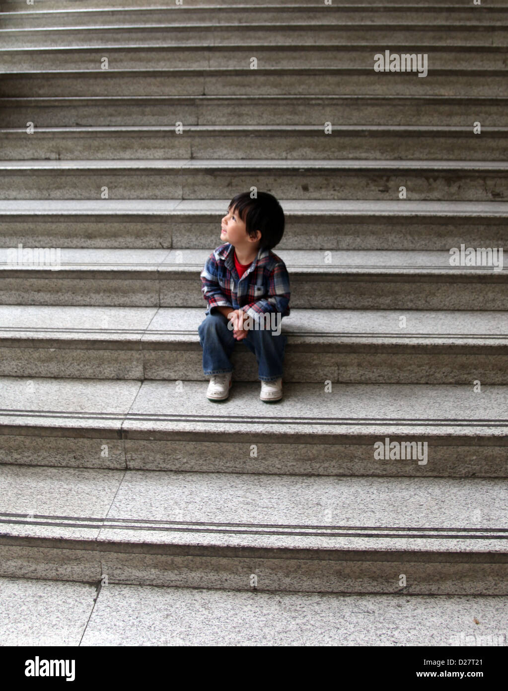 Es ist ein Foto von einem jungen Kind, setzt auf eine Stufe der Treppe ...