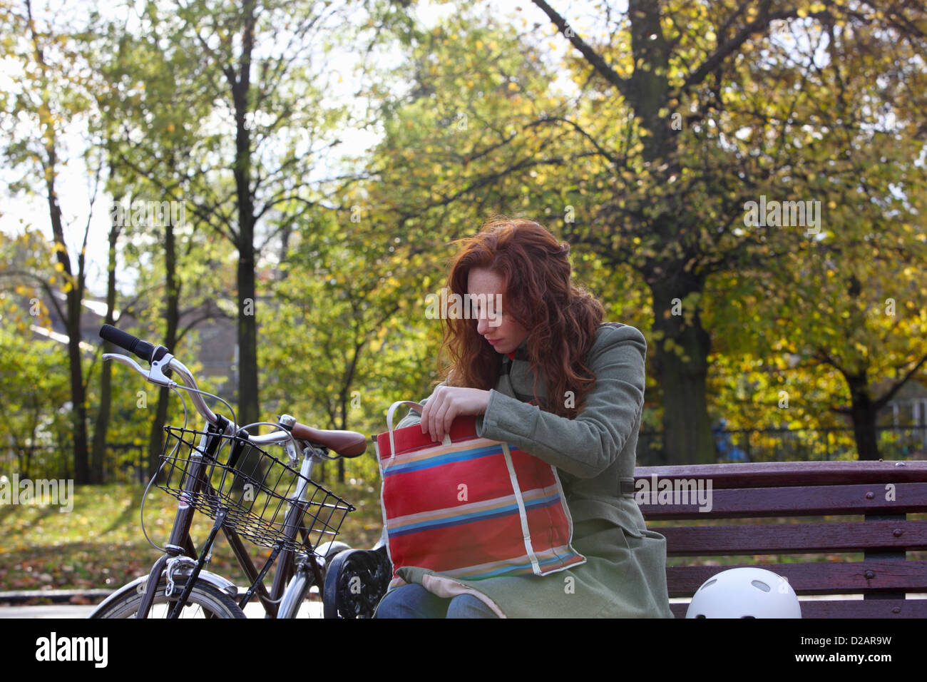 Frau auf der Suche durch Beutel auf Bank Stockfotografie - Alamy