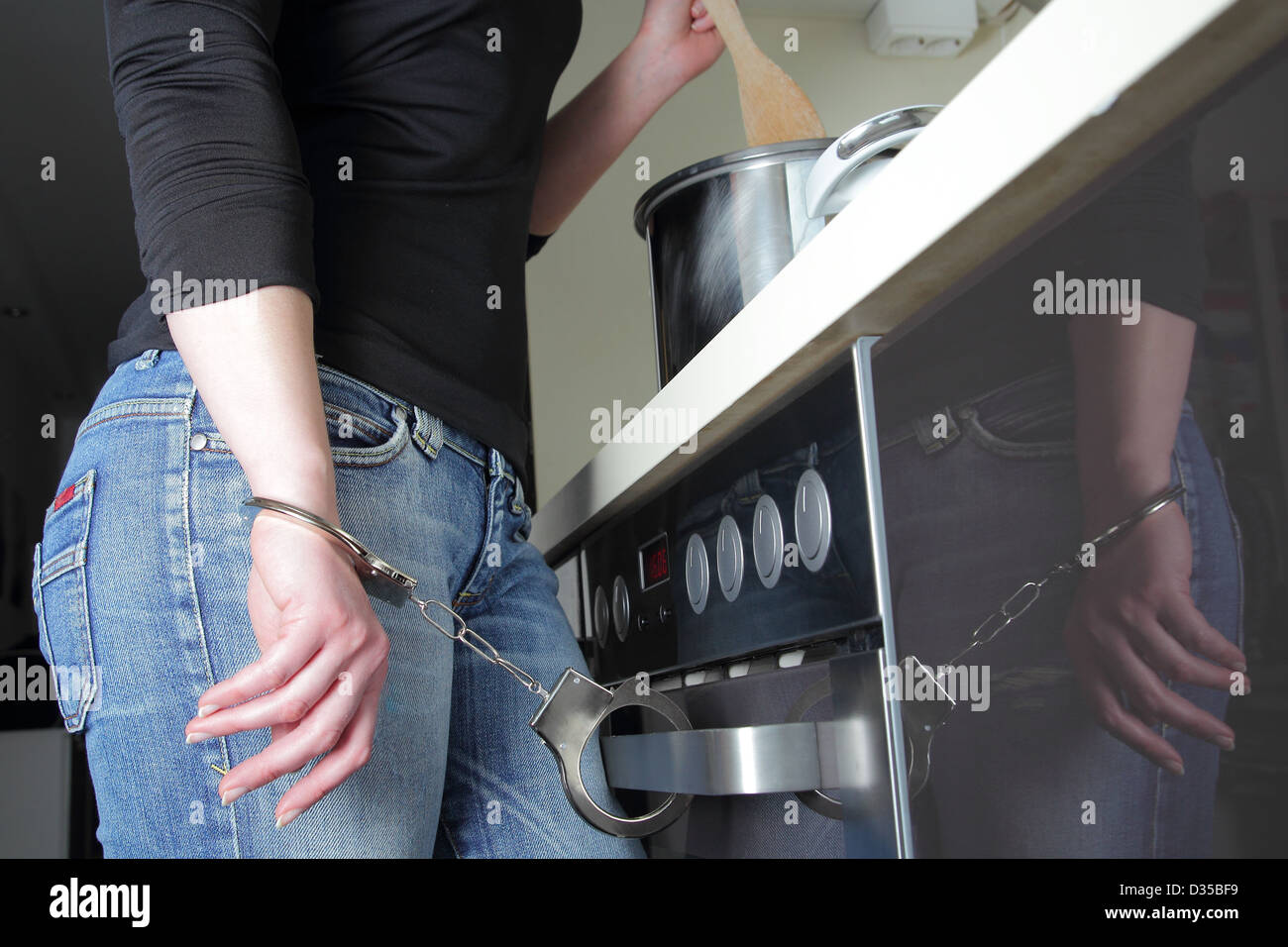 Frau mit Handschellen in der Küche Stockfotografie - Alamy