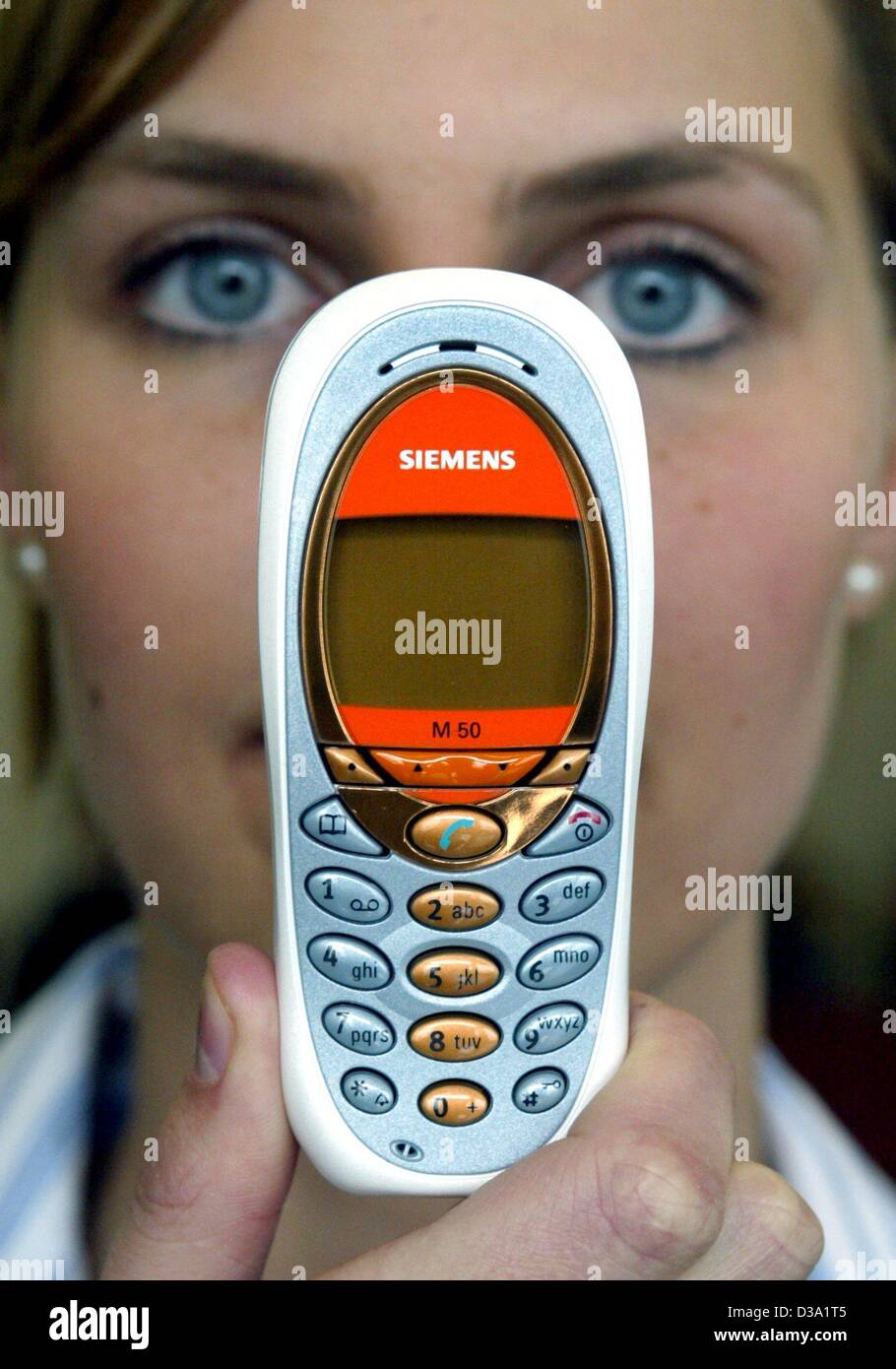 (Dpa) - eine junge Frau präsentiert die neue Siemens-Handy M50 während ...