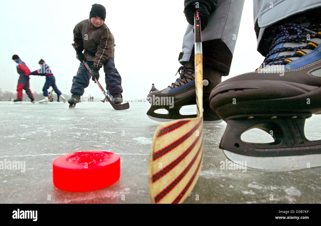 (Dpa) - Boys spielen Eishockey mit einer orange Puck auf dem gefrorenen ...