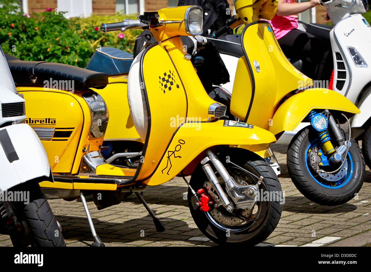 Zwei helle gelbe Lambretta Motorroller, eins mit dem Logo von The Saint ...