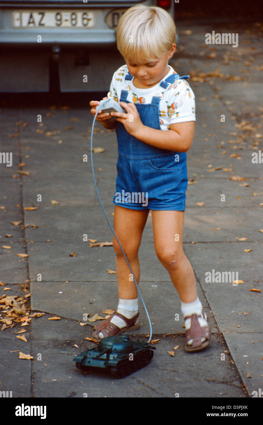 Berlin, DDR, junge spielt auf der Panke hart mit einem Spielzeug Panzer ...