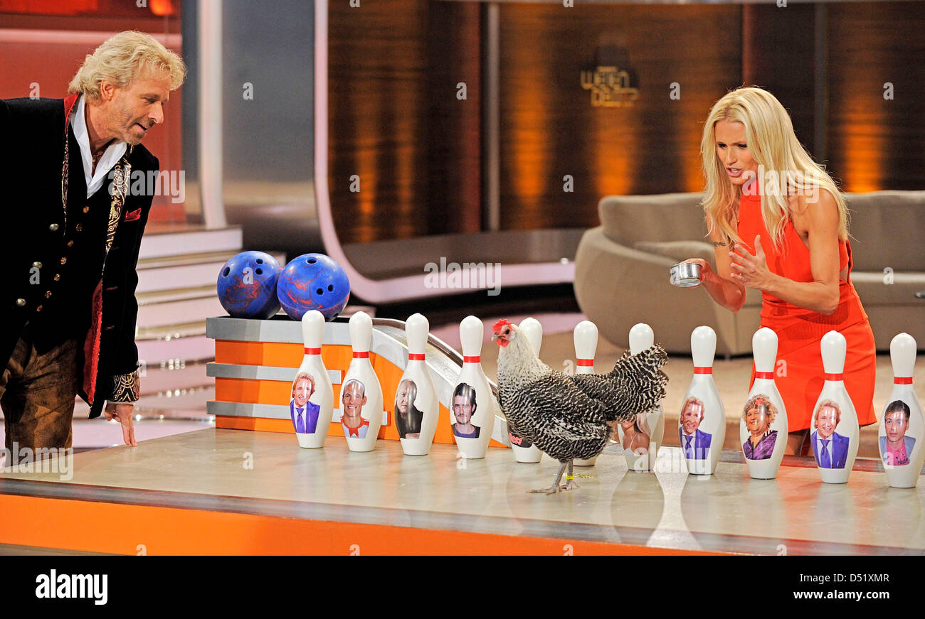 Moderator Thomas Gottschalk (L) und Michelle Hunziker sehen ein Huhn ...