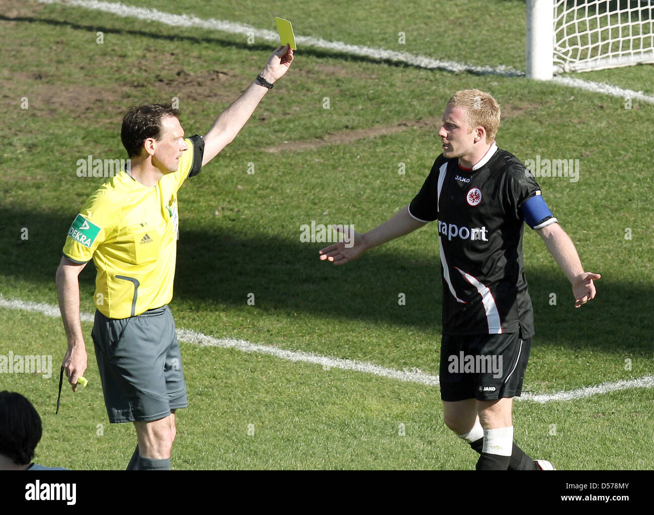 Fußballmannschaften Florian Meyer (L) zeigt der Frankfurter Patrick Ochs (R) die gelbe Karte ...
