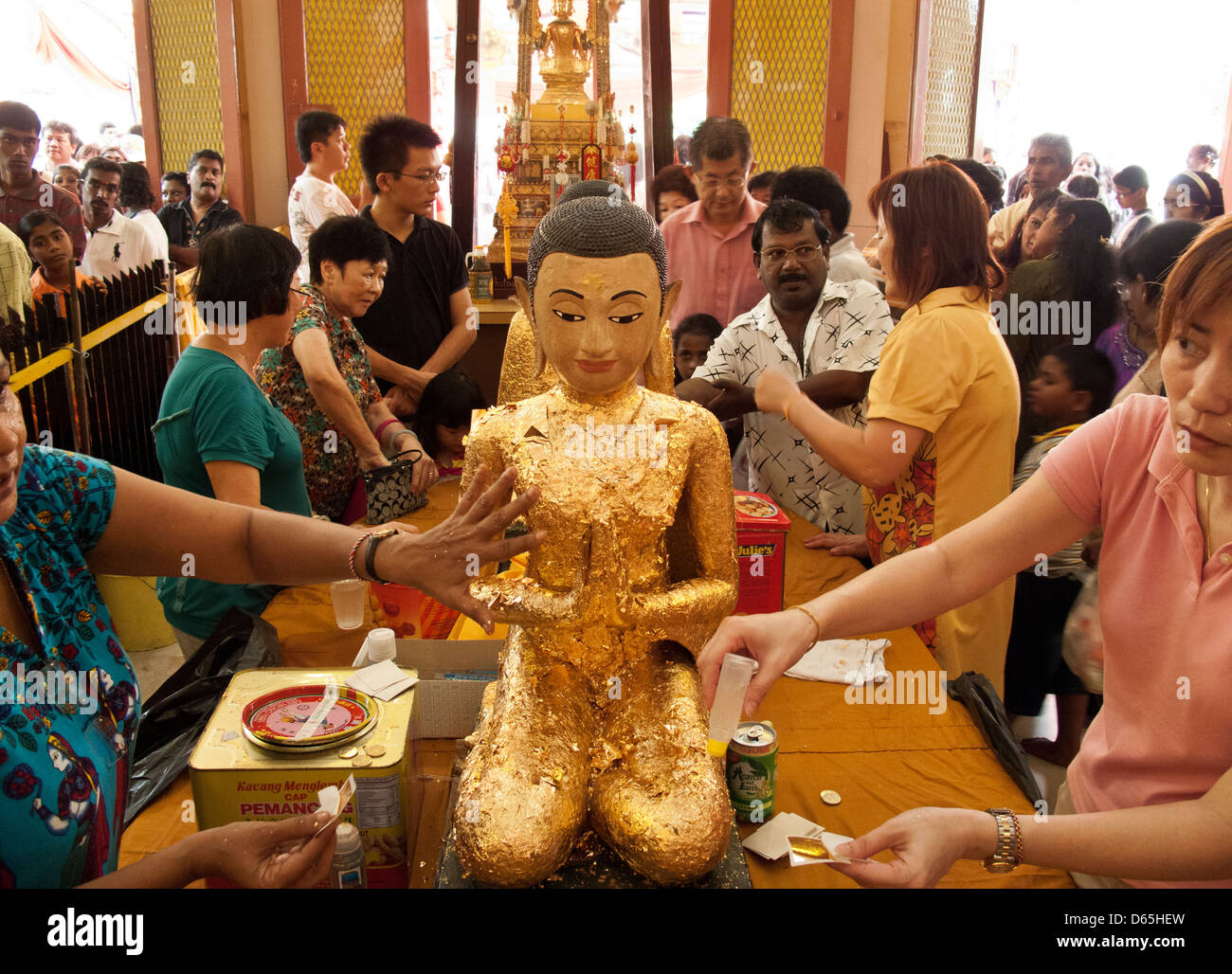Buddhistische Gläubige gelten Blattgold auf eine Buddha-Statue am Vesak ...