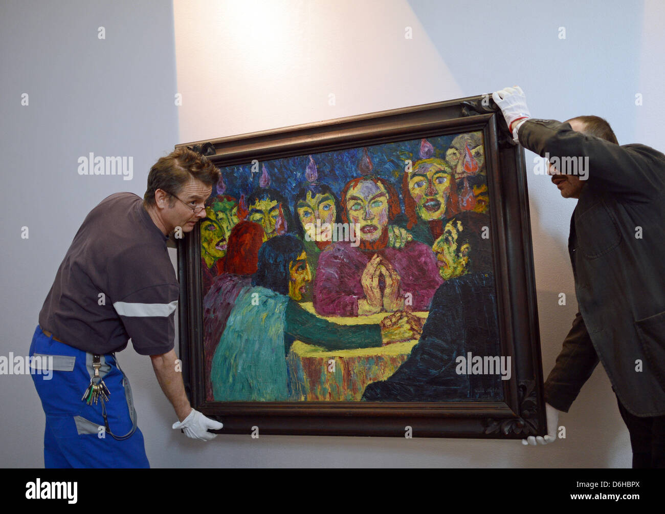 Zwei Mitarbeiter hängen das Bild "Pfingsten" von 1909 durch Emil Nolde im Kunstmuseum Mortizburg ...