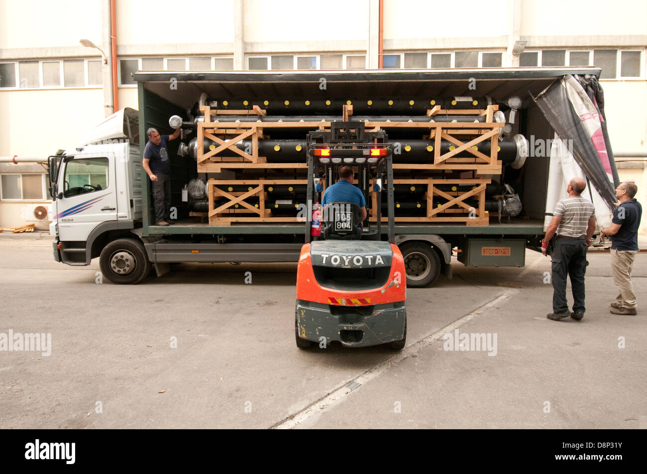 Ein Gabelstapler lädt einen LKW mit einer unregelmäßigen Palette von ...