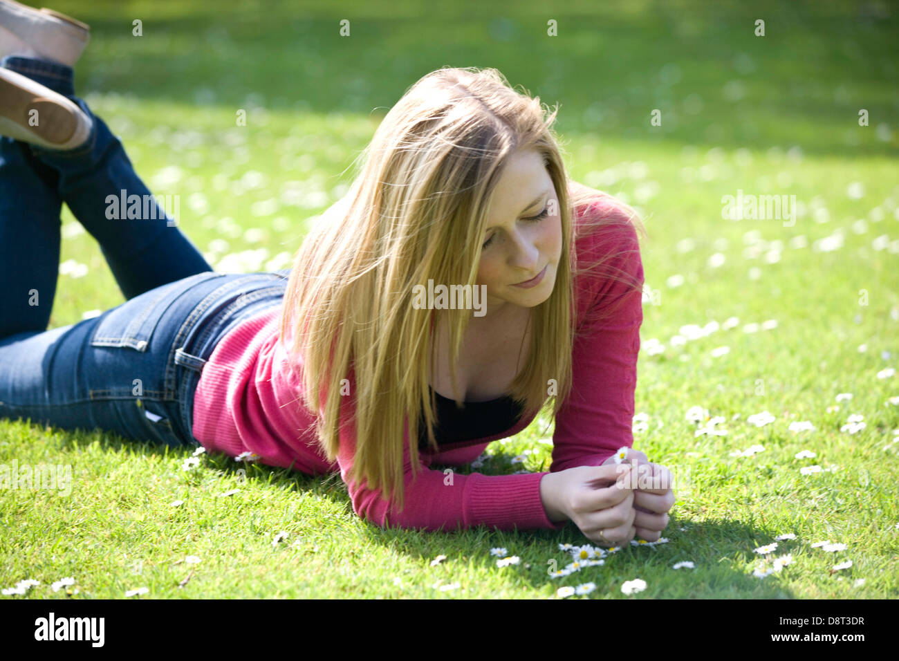 Junge Frau in einem Park hält ein Gänseblümchen hinlegen ...