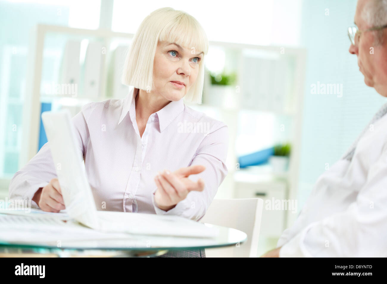 Porträt von Reife Geschäftsfrau Blick auf ihr Partner beim Gespräch mit ihm am Arbeitsplatz ...