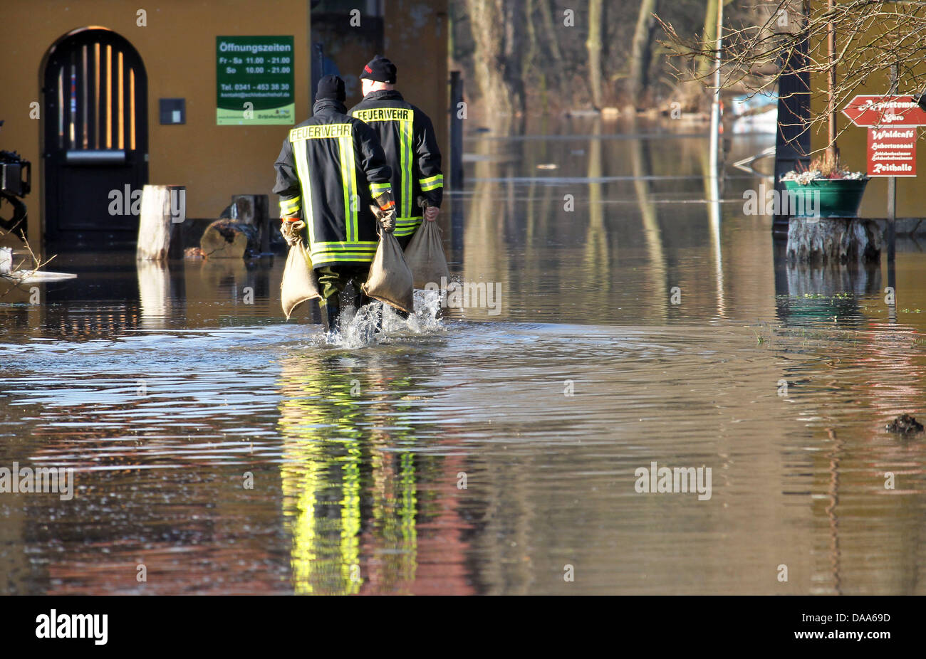 Ein Feuerwehrmann trägt Sandsäcke durch Weisse Elster Fluss in Leipzig ...