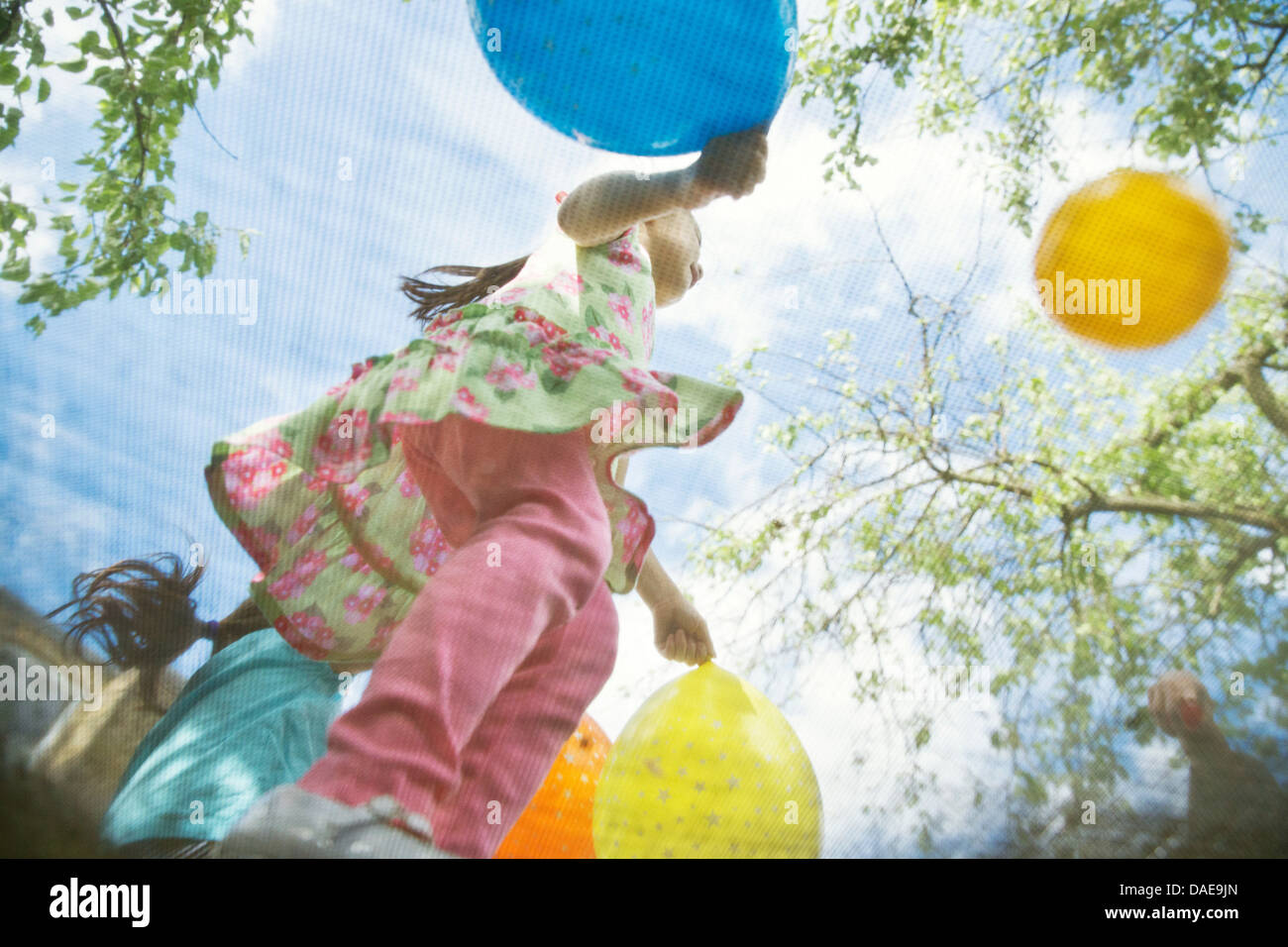 Junge Mädchen Prellen auf Gartentrampolin mit Luftballons ...
