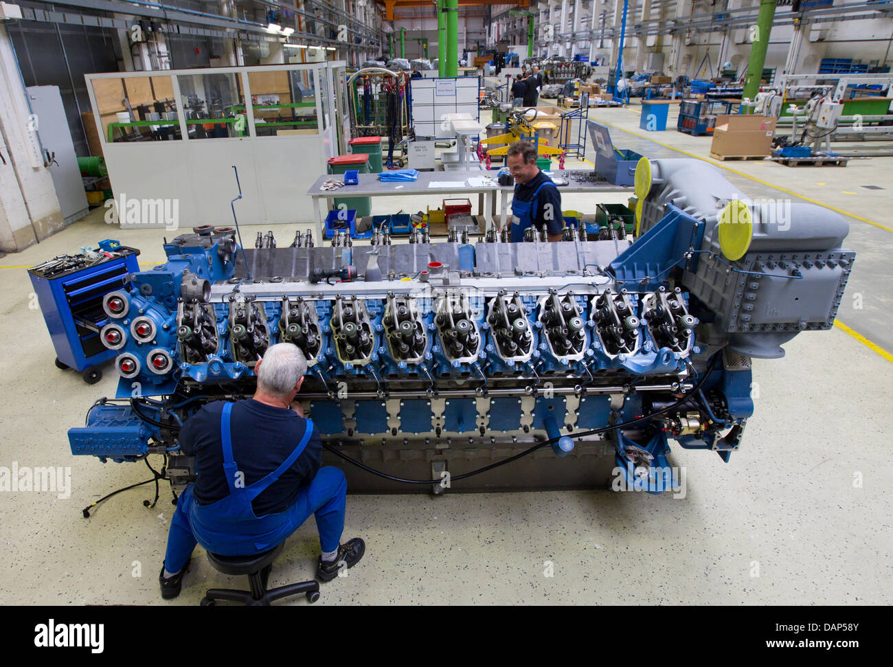 Mitarbeiter sind bei Diesel-Motoren in einer Montagehalle der Firma SKL ...