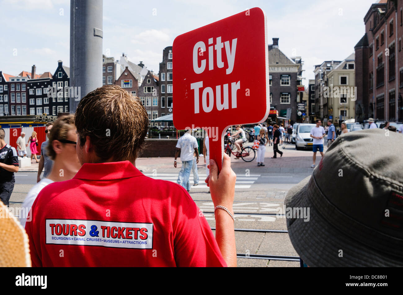 Eine Tourguide hält ein Schild für die Stadtrundfahrt in Amsterdam ...