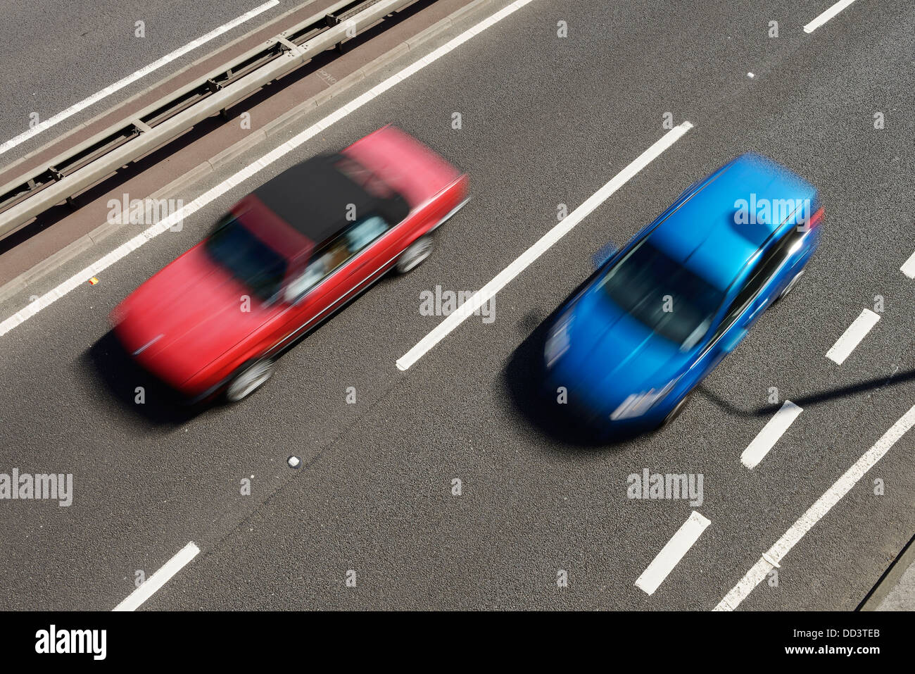 Draufsicht auf ein rotes Auto und ein blaues Auto auf einer Straße zu ...
