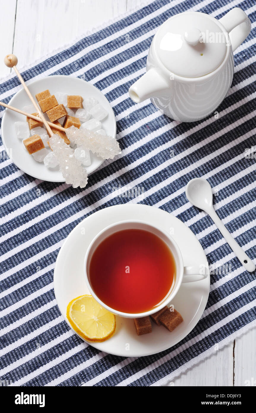 Tasse mit Tee und Teekanne auf blau gestreiften Hintergrund ...