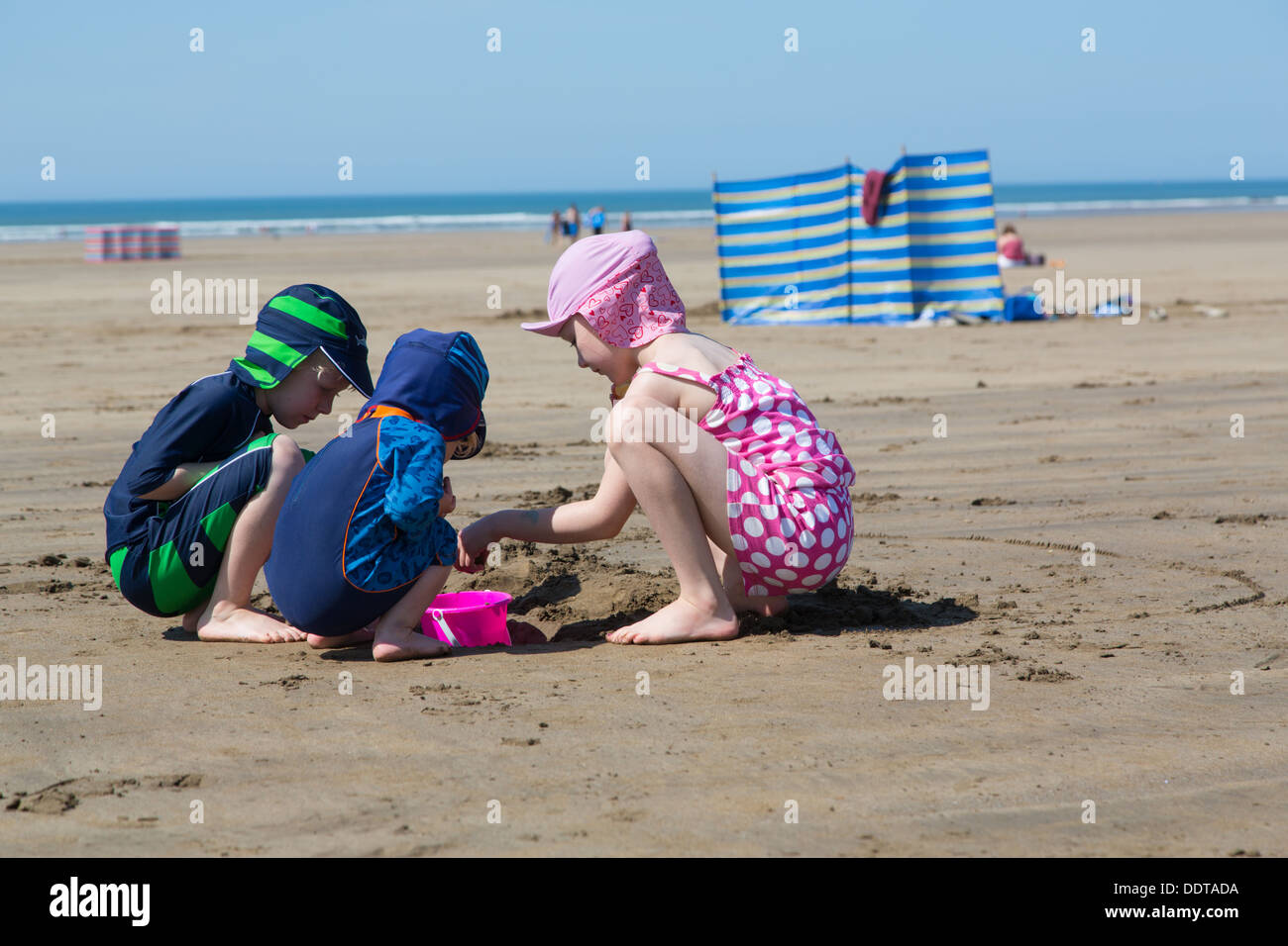 Drei kinder spielen am strand -Fotos und -Bildmaterial in hoher ...