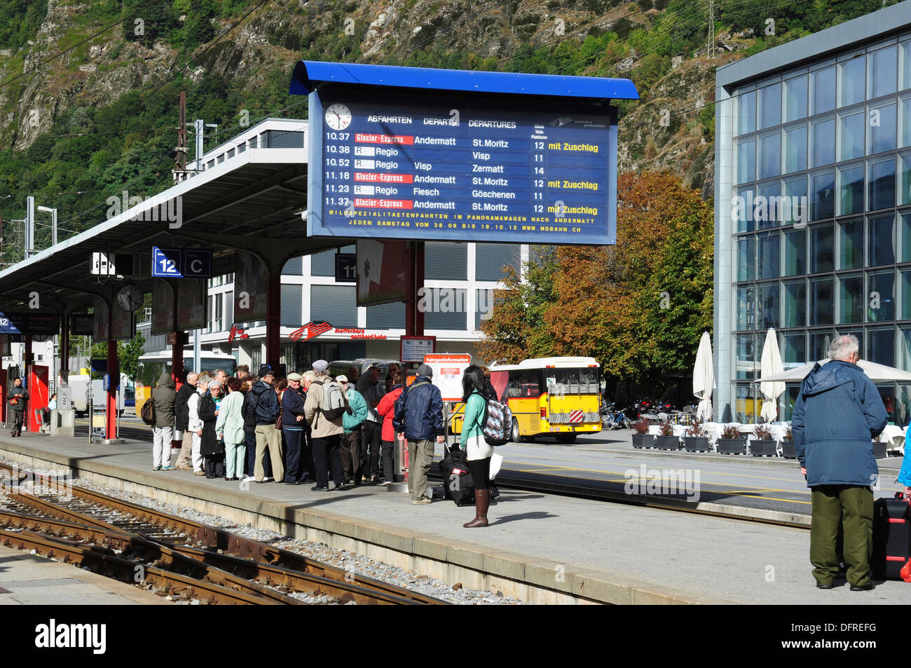 Passagiere und Zug Abfahrt Informationstafel am Bahnhof Brig, Wallis ...