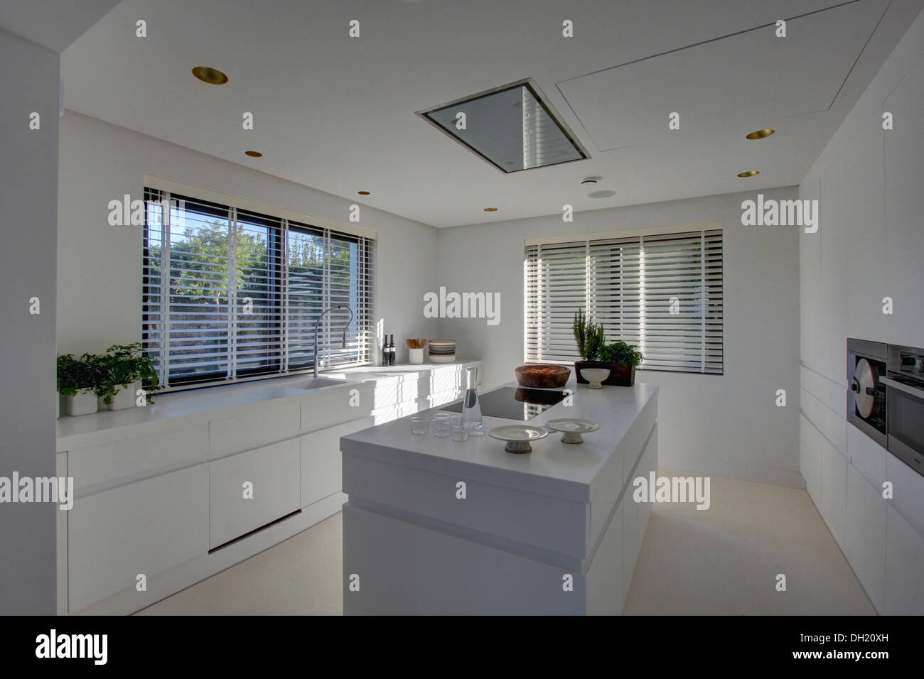 Insel-Einheit in modernen weißen Küche mit weißen Jalousien an den ...