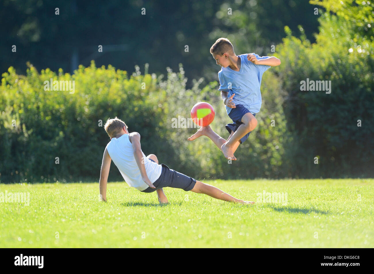 Zwei Jungs im Teenageralter Fußball spielen auf einer Wiese, Oberpfalz ...
