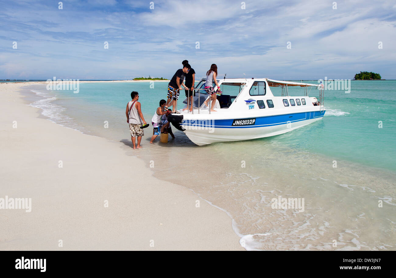 Menschen-Jumping von einem Boot am langen Strand von Tiga Insel Borneo ...